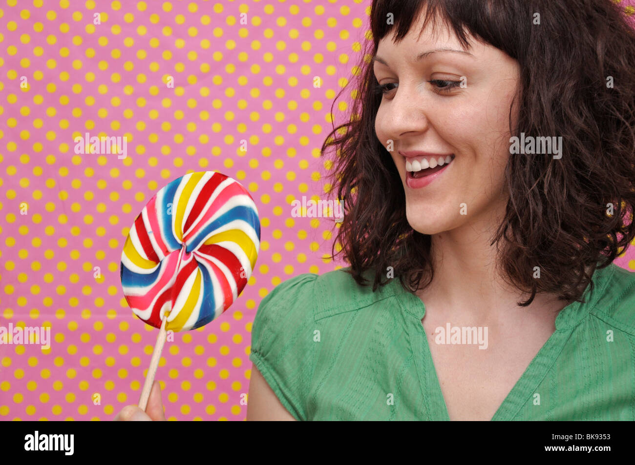Smiling young woman holding lollipop Stock Photo - Alamy