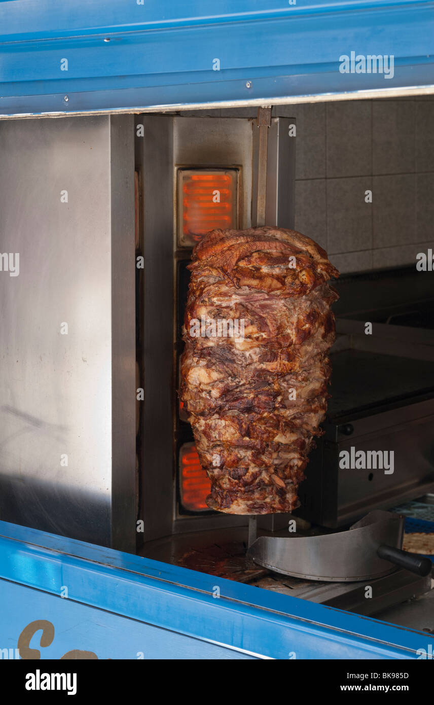 Gyros skewer turning through a vertical broiler in Greece Stock Photo ...