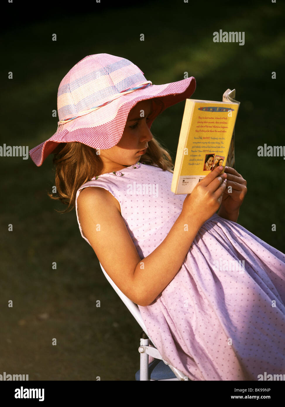 Girl In Pink Dress Reading Book, Day Stock Photo - Alamy