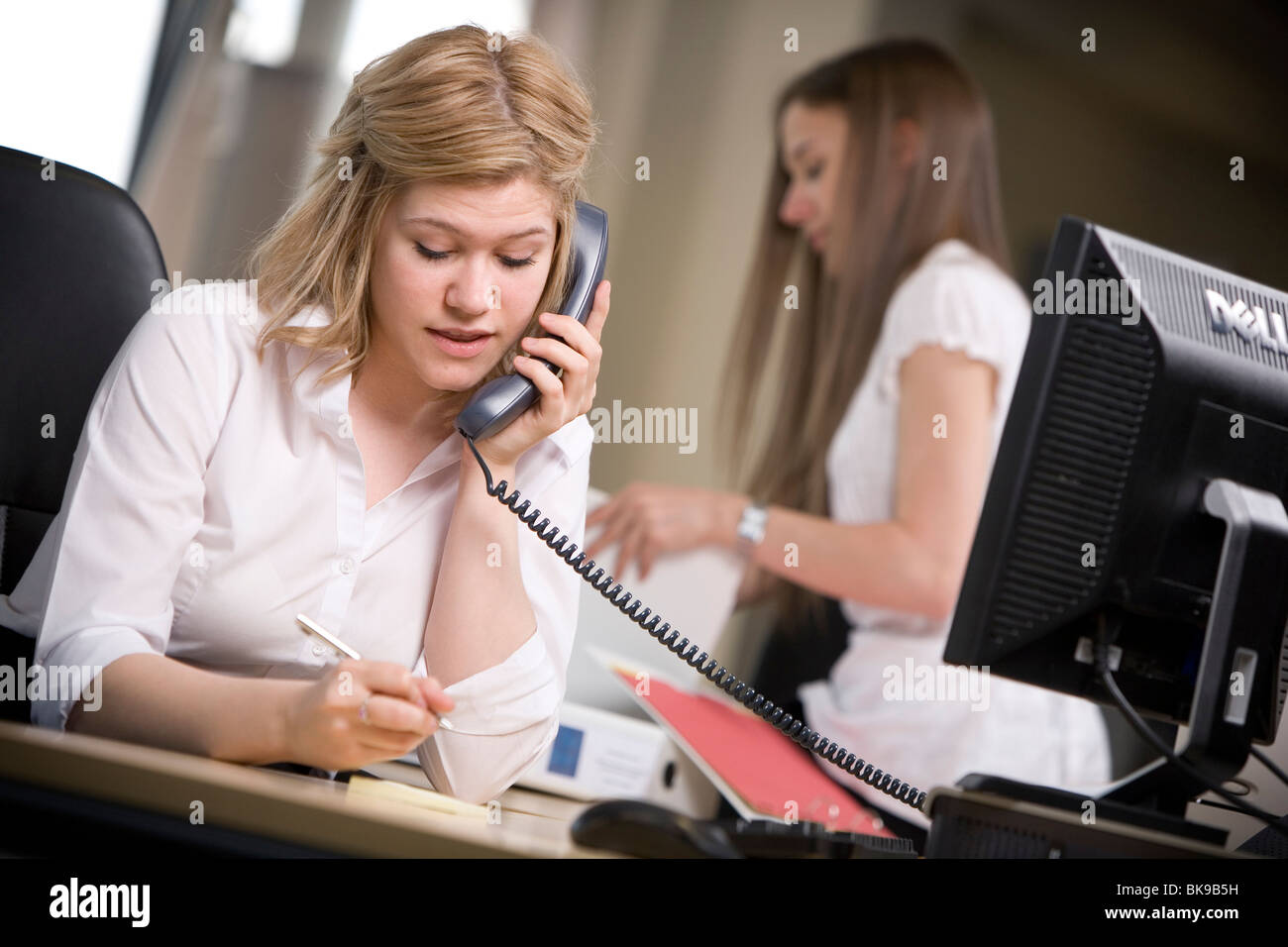 Happy secretary takes a phone call in the office Stock Photo - Alamy
