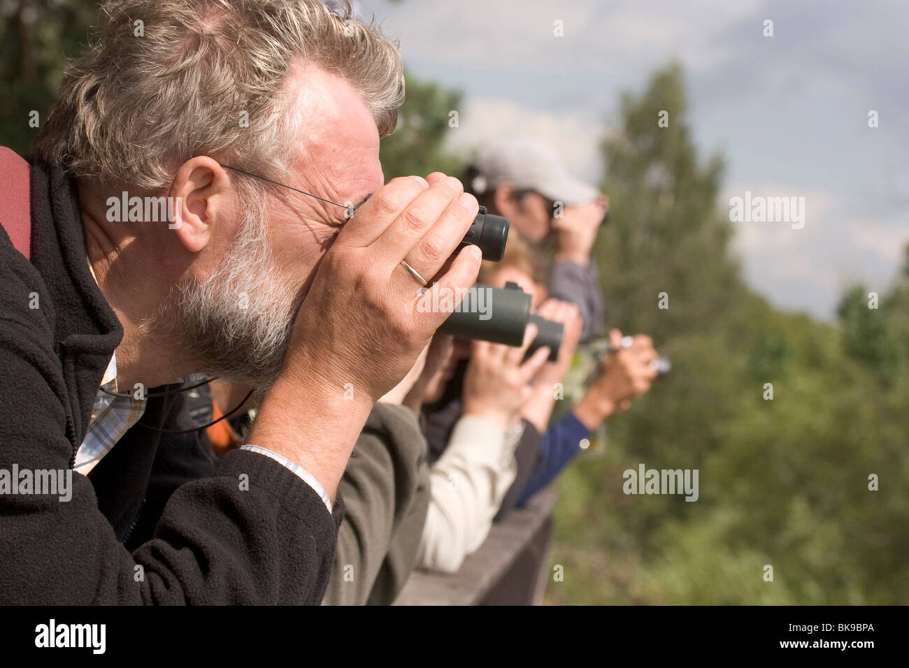 People with binoculairs and cameras looking in the distance Stock Photo ...