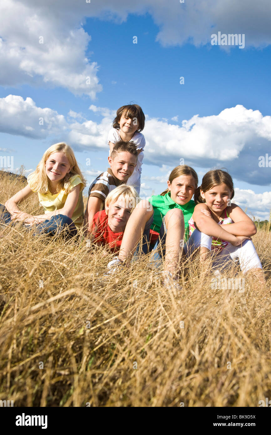 A group of children sitting in the grass, laughing Stock Photo - Alamy