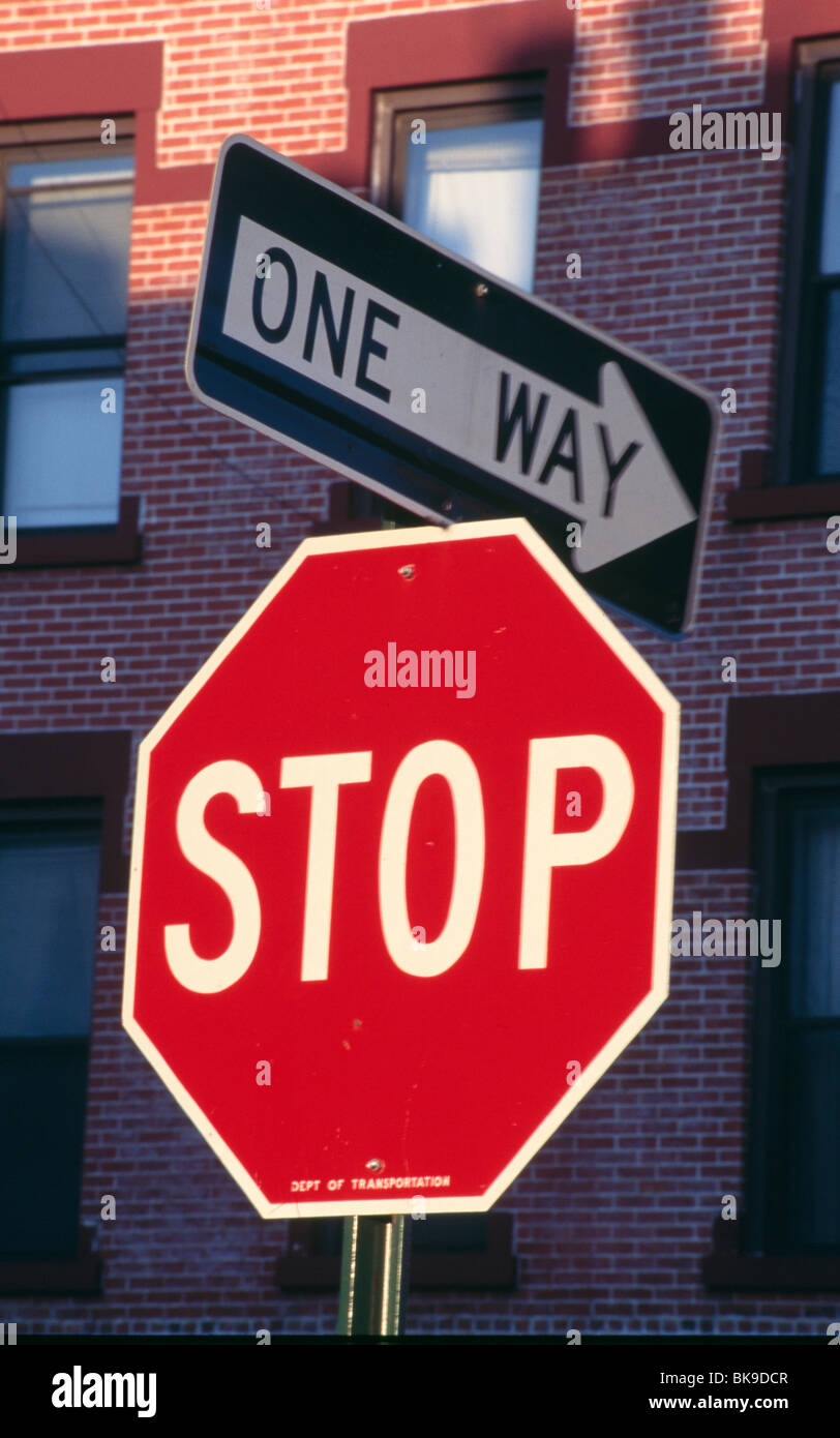 Stop sign with one way arrow, building exterior on the background Stock ...