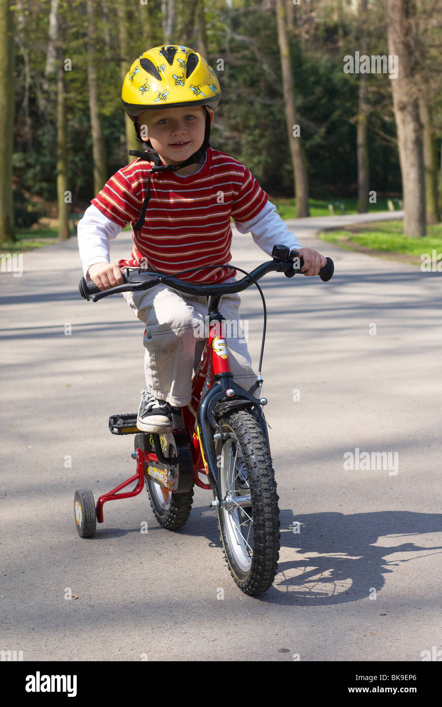 Boy Learning to Ride Bicycle with stabilizing wheel bike Stock Photo ...