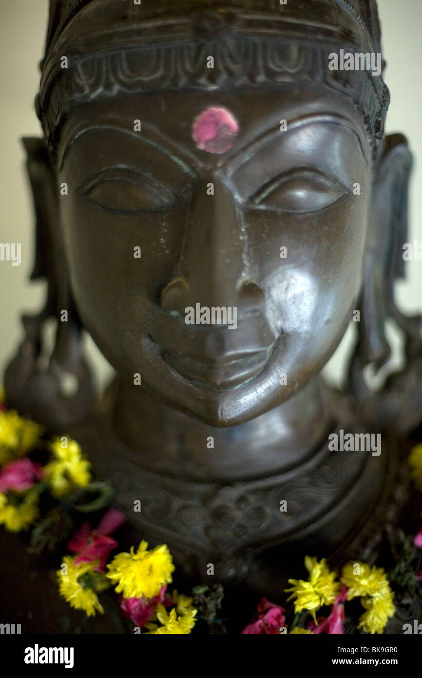 A detail of an idol decorated with flowers at the Sterling Swamimalai ...