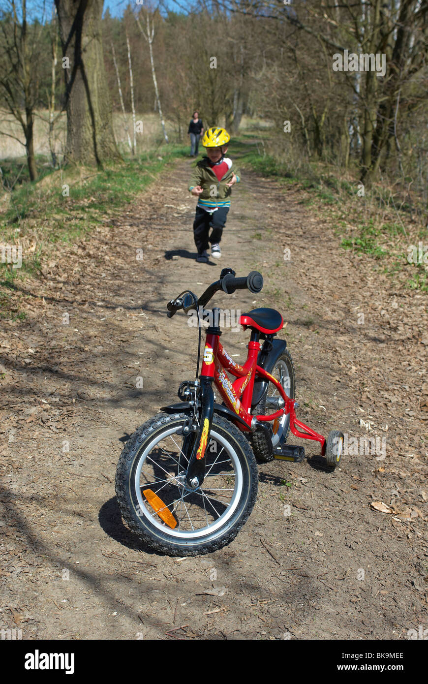 Boy Learning to Ride Bicycle with stabilizing wheel bike Stock Photo ...