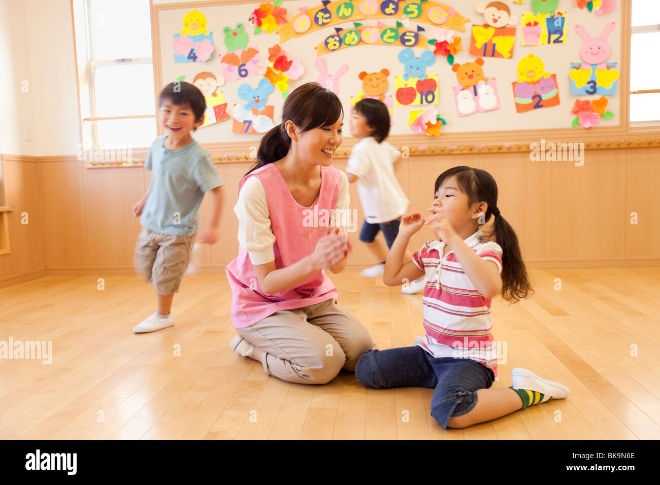 Nursery Teacher and Children Playing at Day-care Center Stock Photo - Alamy