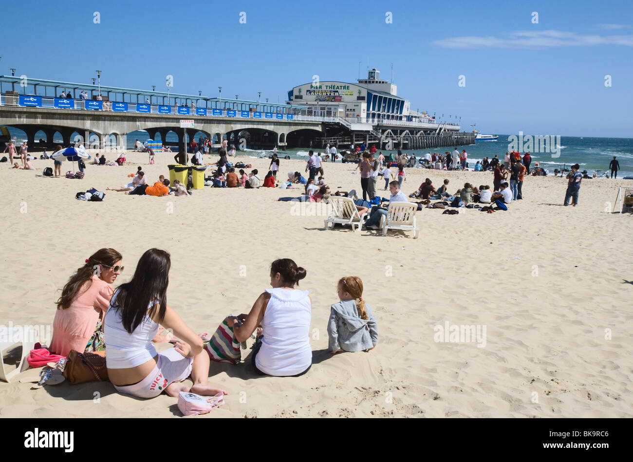 People relaxing at beach, pier with Pier Theatre in background ...
