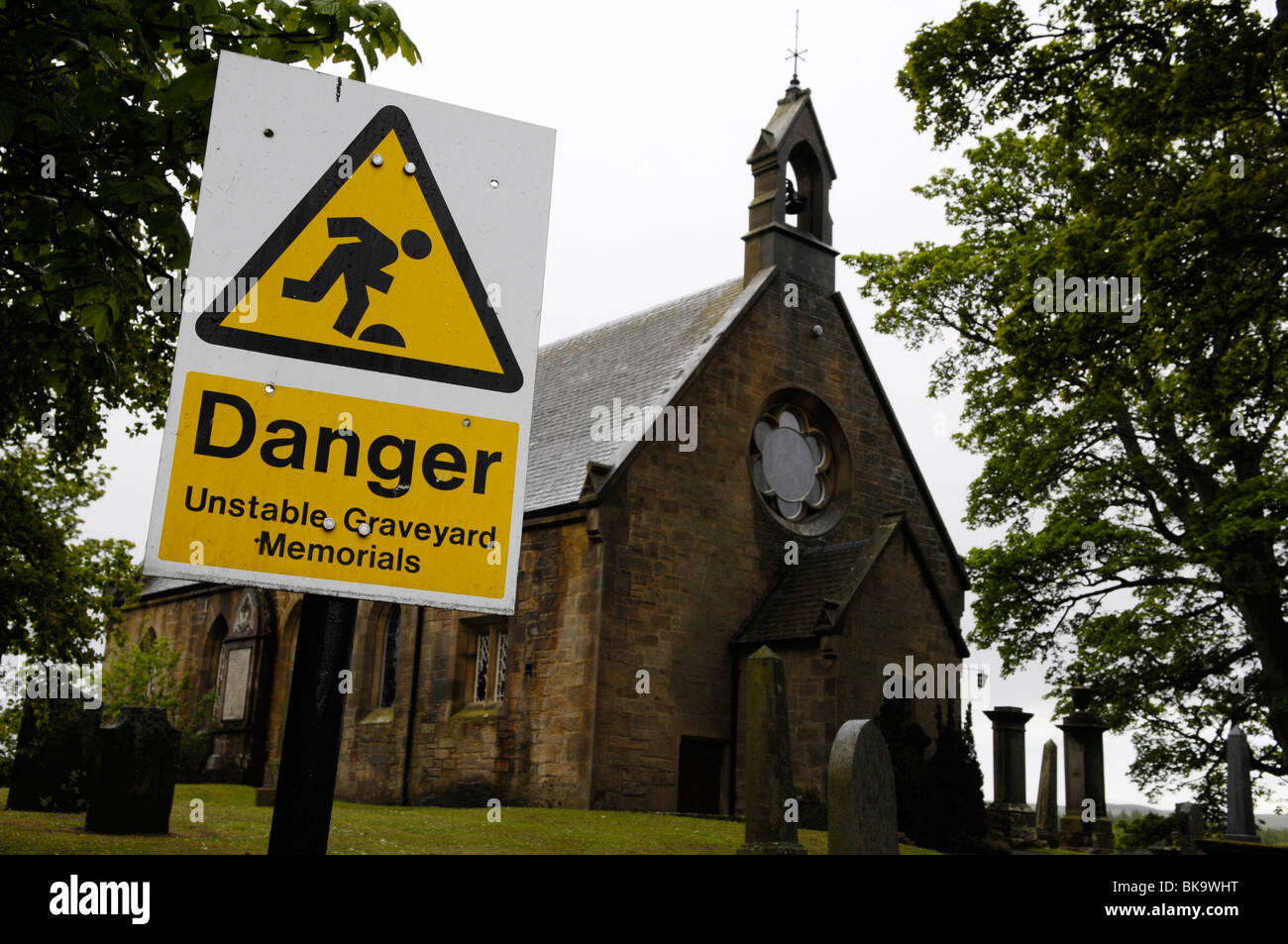 A sign in a church graveyard warns of unsafe headstones the sign says ...