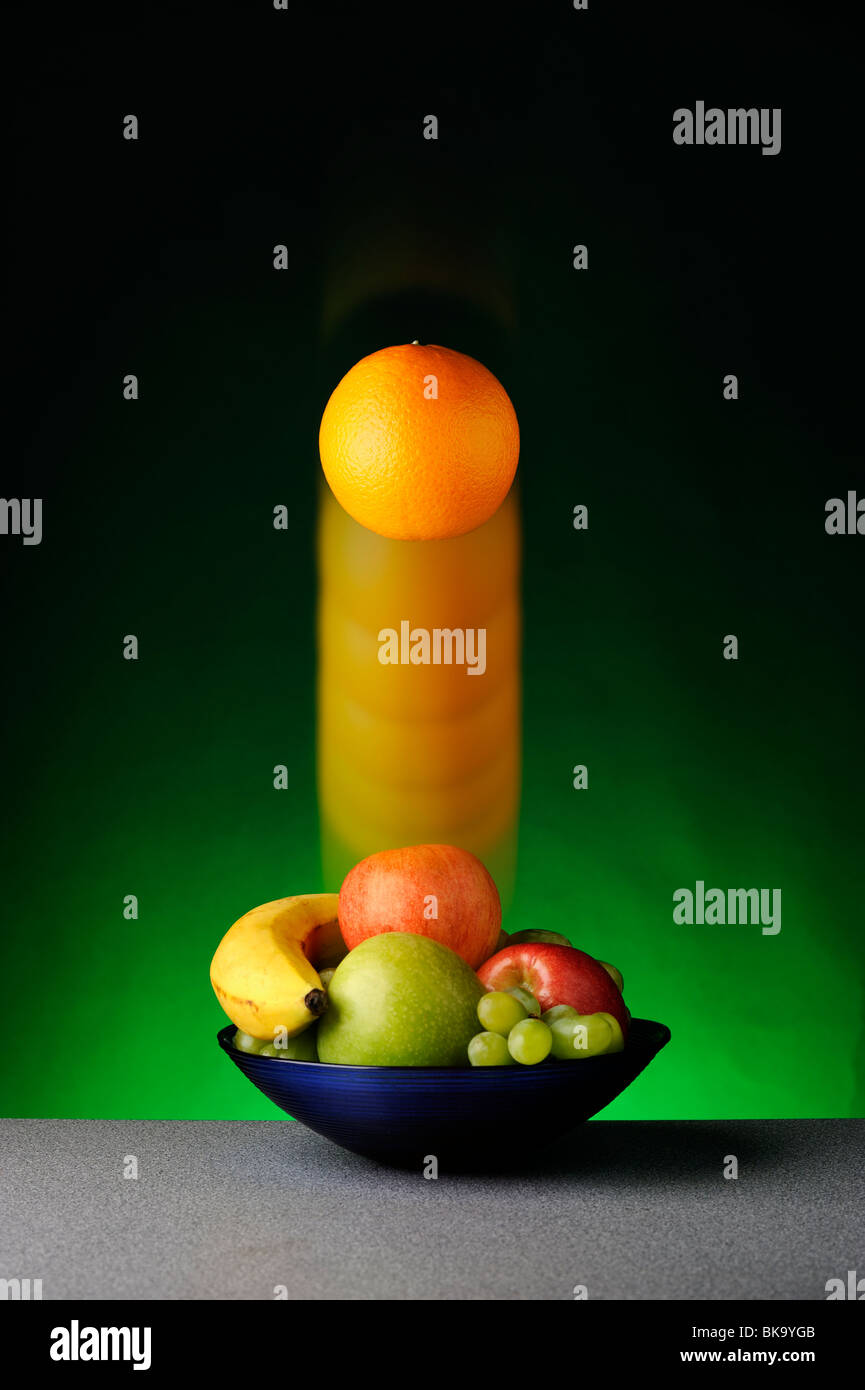 Orange rising from fruit bowl Stock Photo - Alamy