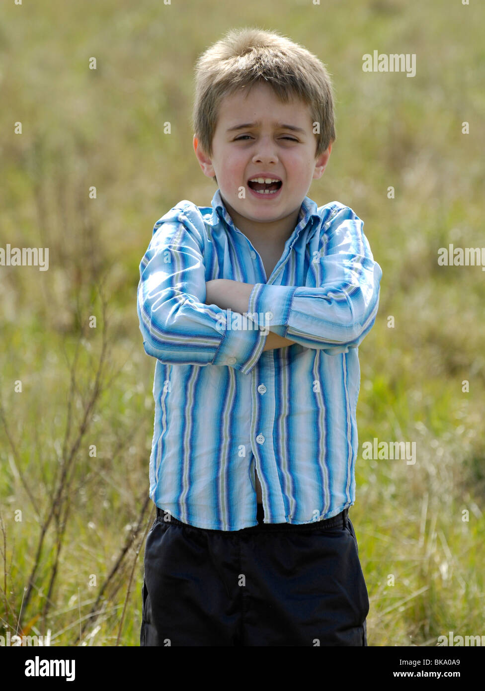 Vertical image of a Young boy walking in a field on his own Stock Photo ...