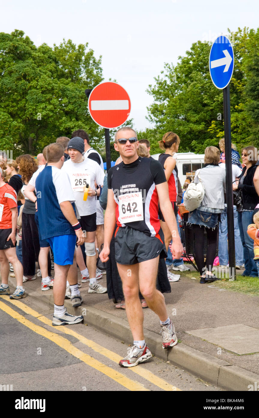 Large crowd of people and some runners waiting for the start of a 10KM ...