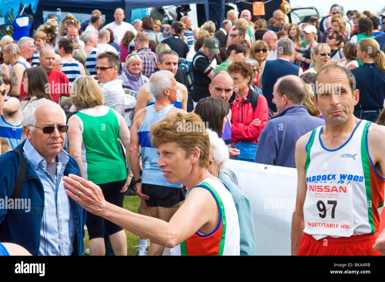 Large crowd of people and some runners waiting for the start of a 10KM ...