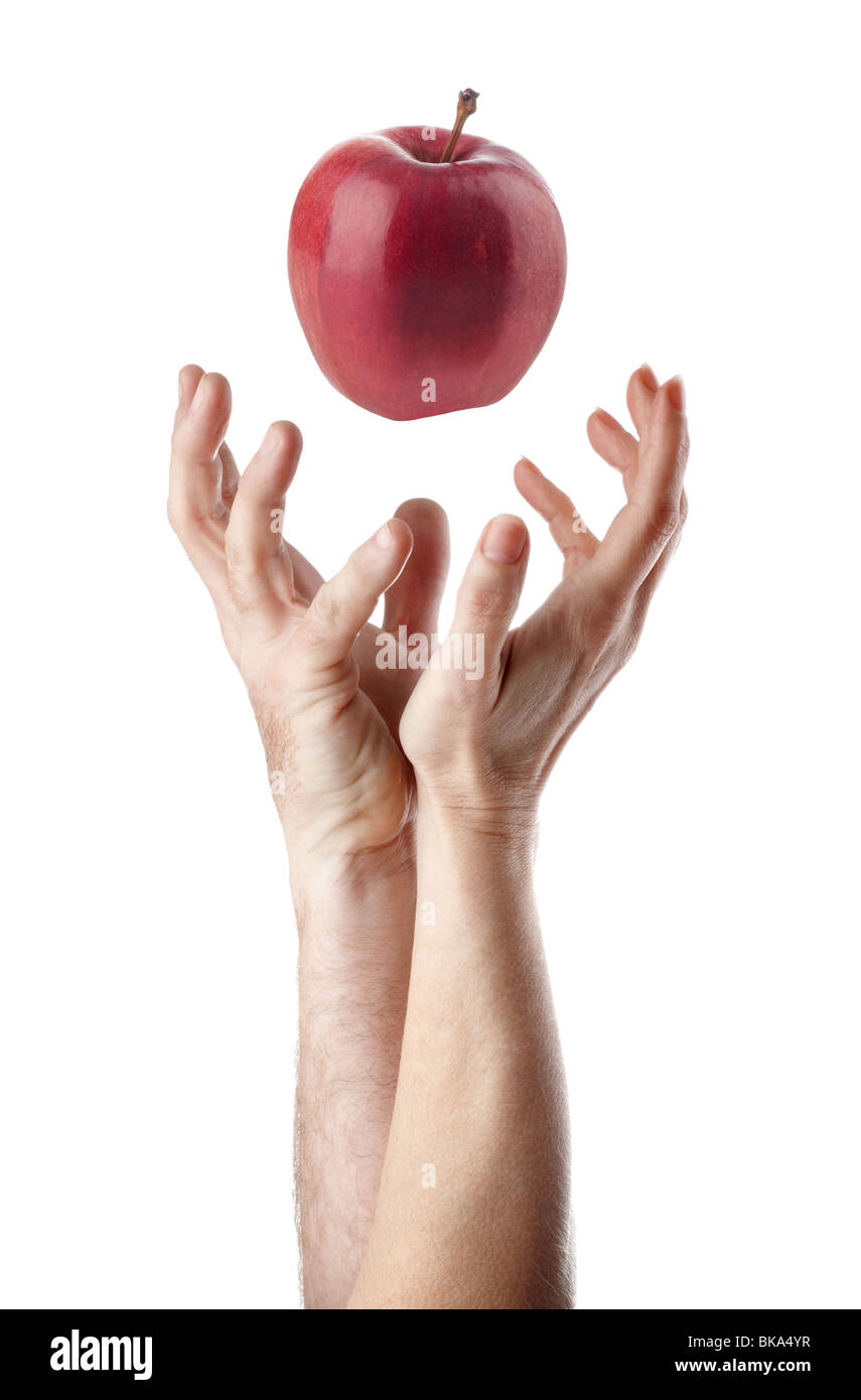 Man and woman hand trying to catch an apple Stock Photo - Alamy