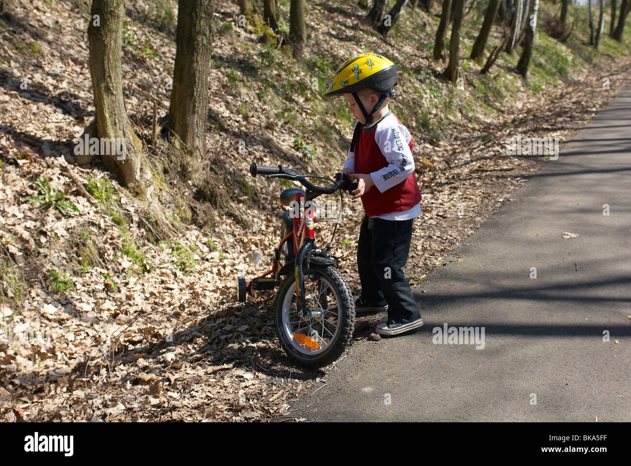 Boy Learning to Ride Bicycle with stabilizing wheel bike Stock Photo ...