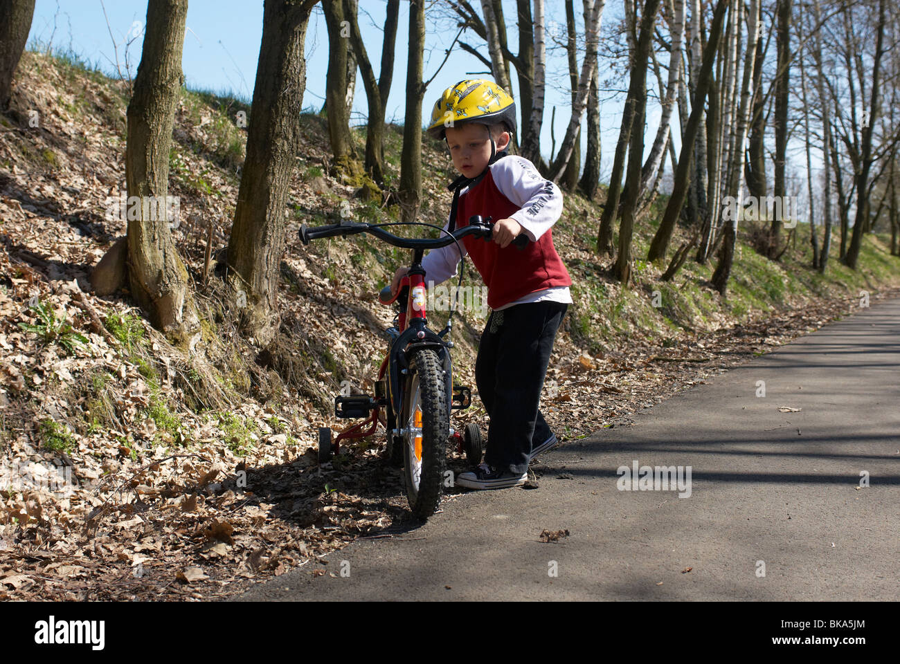 Boy Learning to Ride Bicycle with stabilizing wheel bike Stock Photo ...