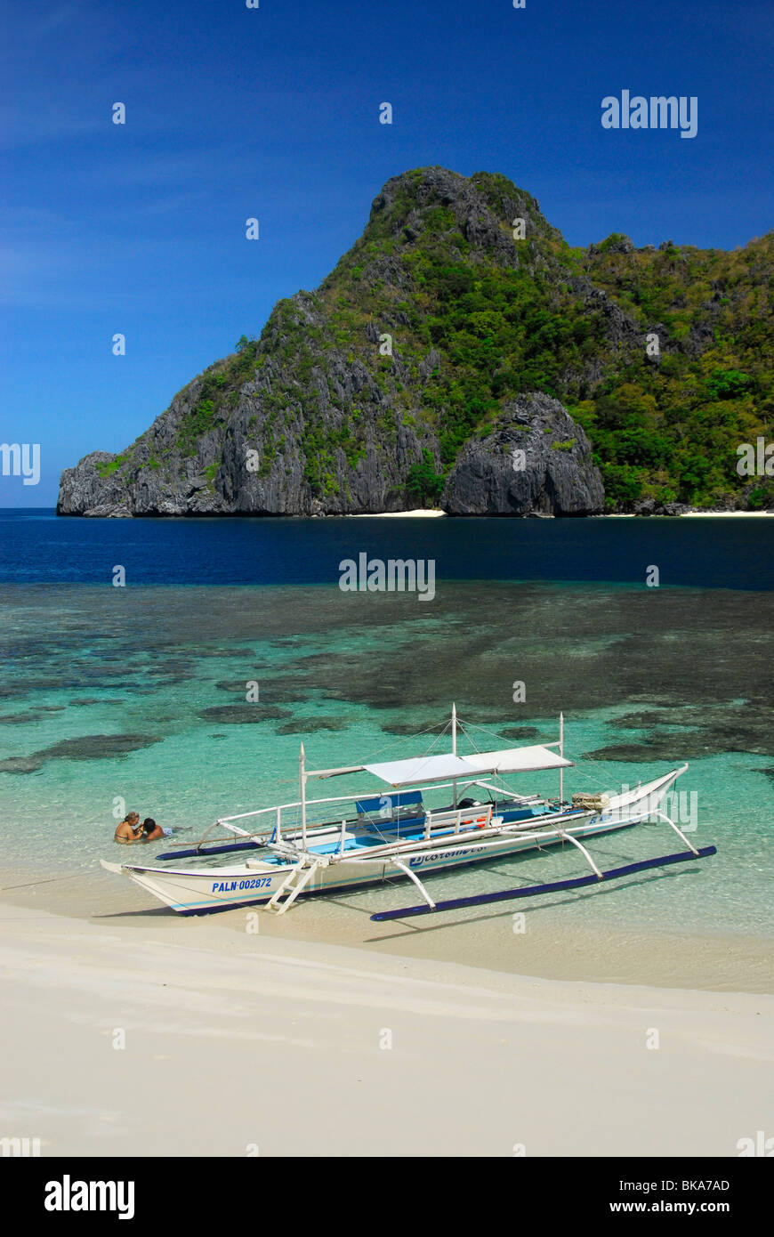 Sunbathing couple in a bay in El Nido area, Palawan, Philippines ...