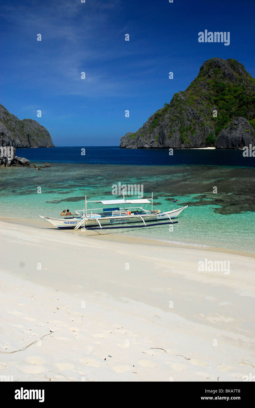 Sunbathing couple in a bay in El Nido area, Palawan, Philippines ...