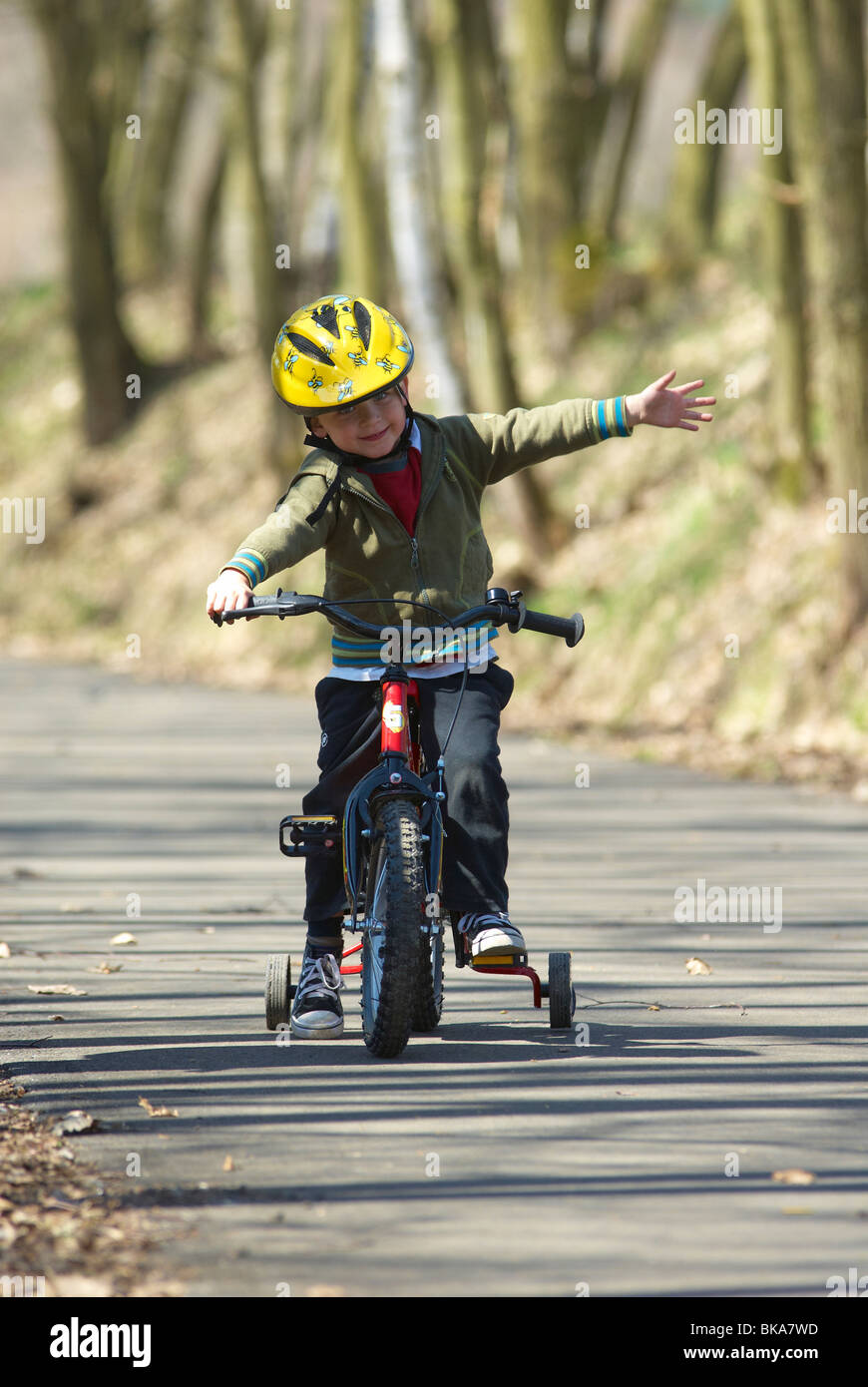 Boy Learning to Ride Bicycle with stabilizing wheel bike Stock Photo ...