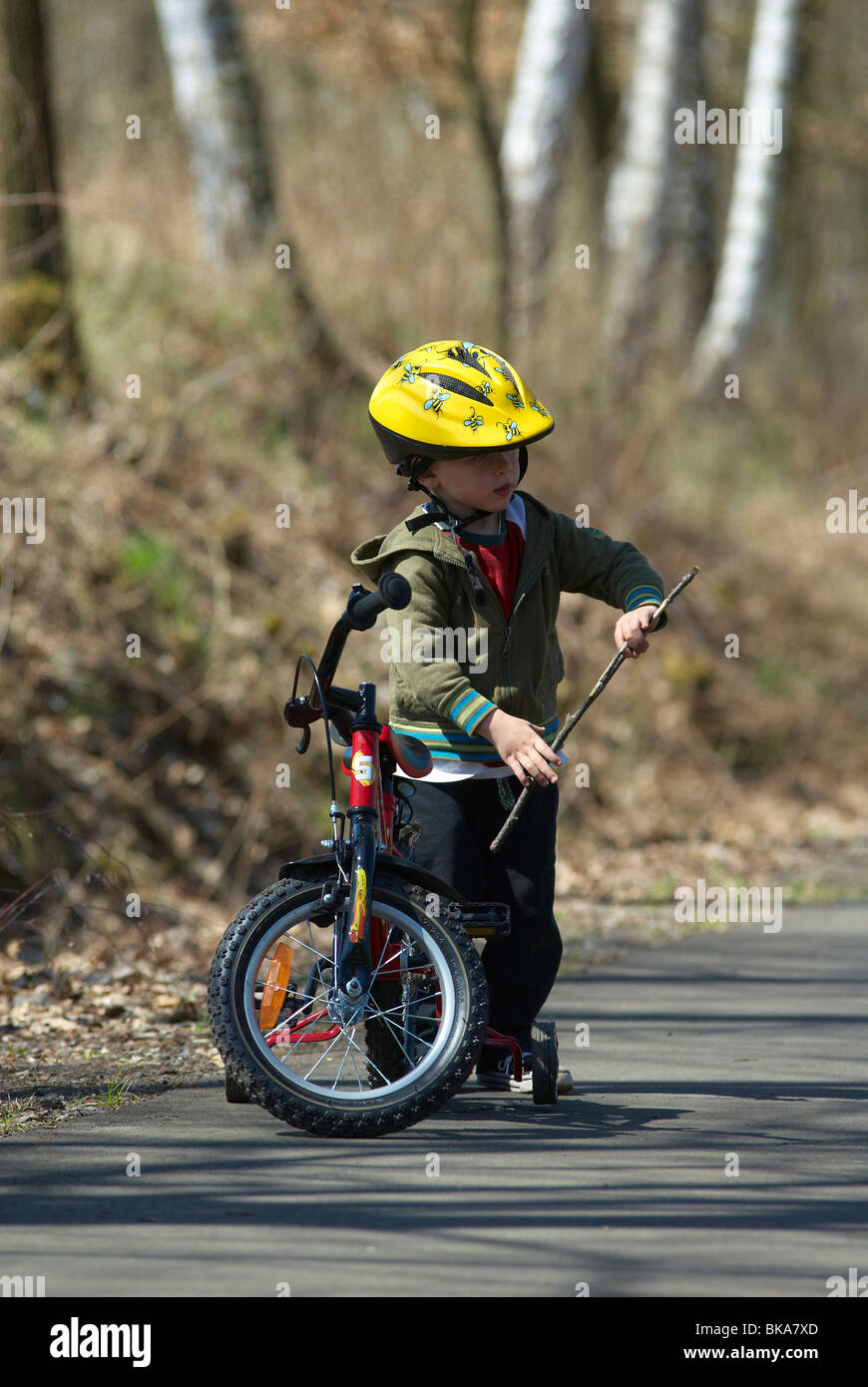 Boy Learning to Ride Bicycle with stabilizing wheel bike Stock Photo ...