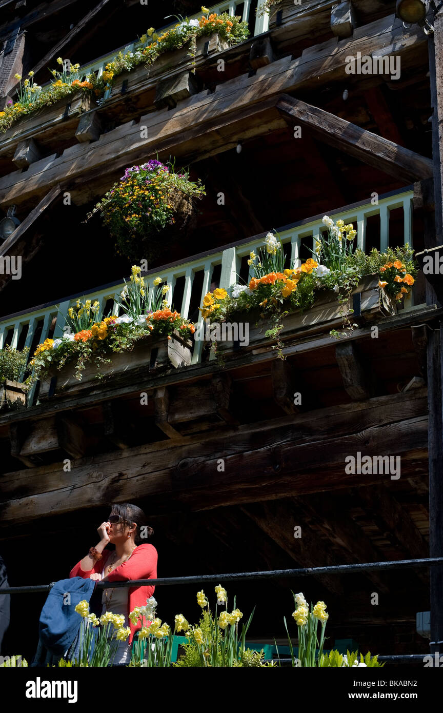 A woman standing on a balcony of the Dickens Inn pub in London Stock ...