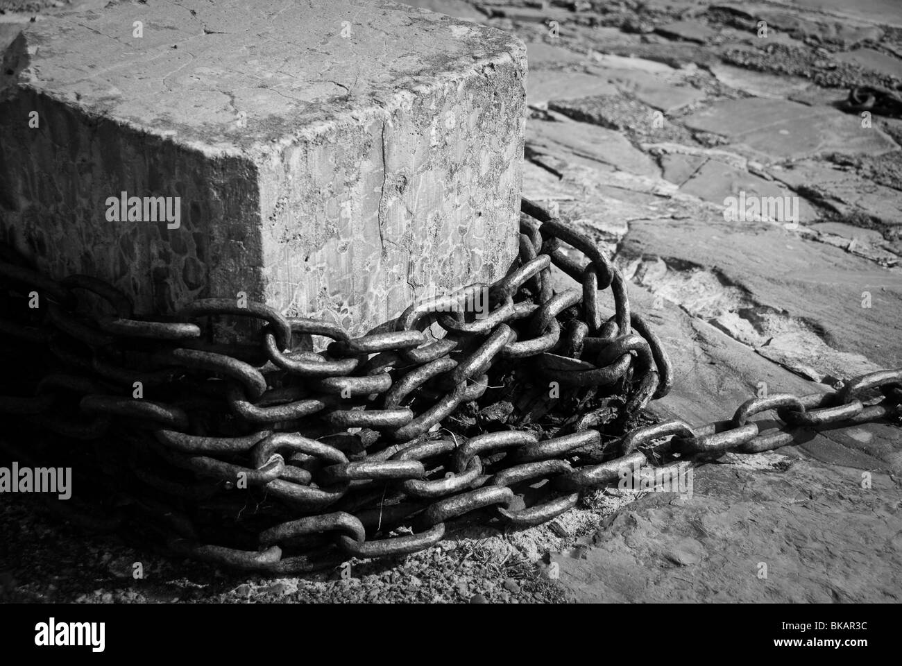 Black and white photograph of a chain wrapped around a concrete post ...