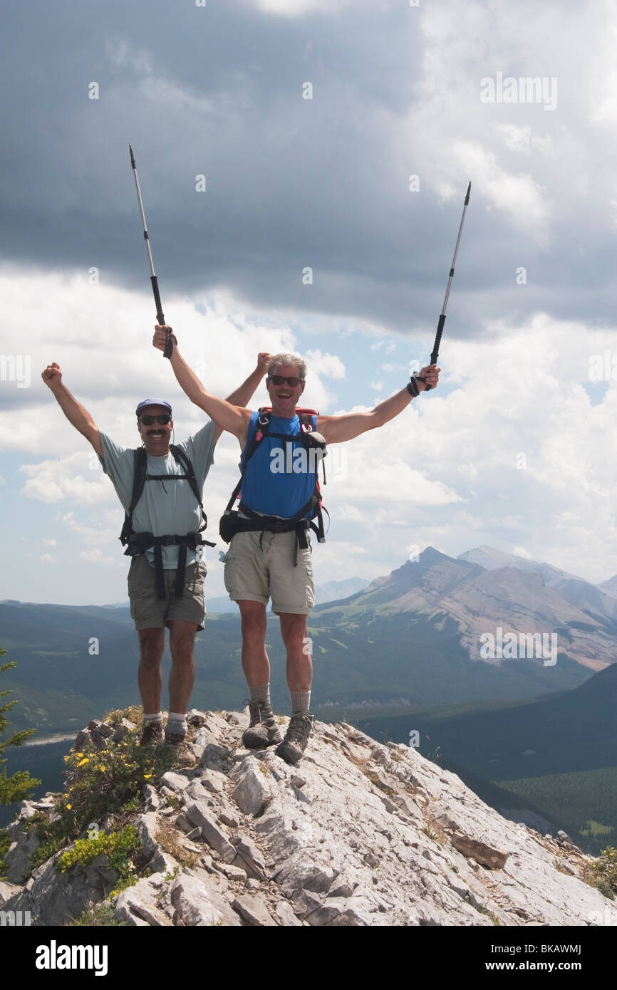 Two Men Cheering At The Top Of A Mountain Stock Photo - Alamy