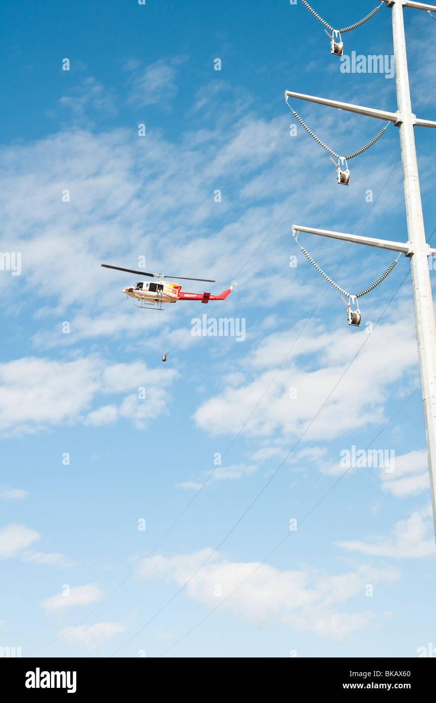 a helicopter is used to string a cable during construction of a new ...