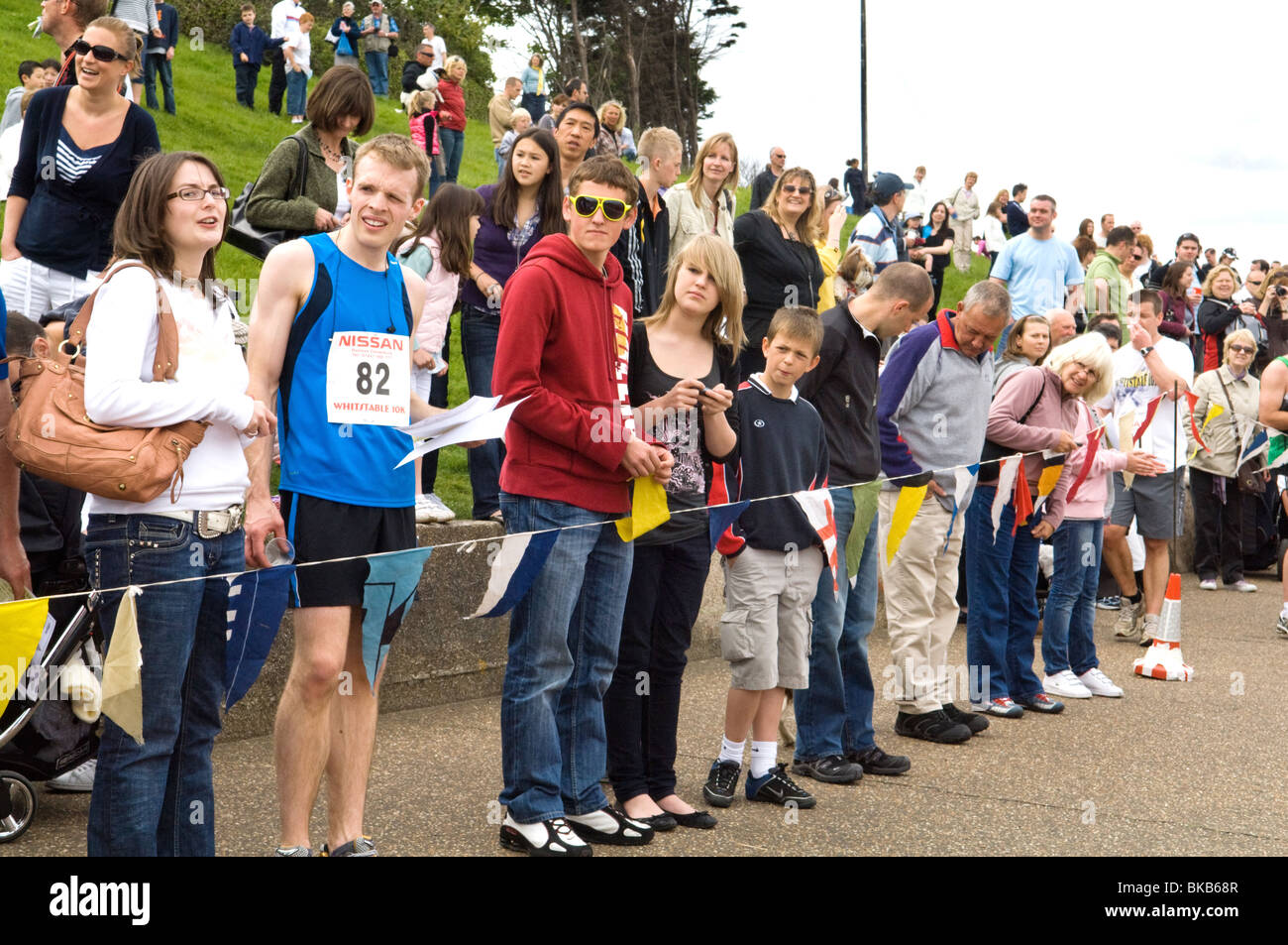 Colourful crowd of spectators at a 10KM charity run, teenager in the ...
