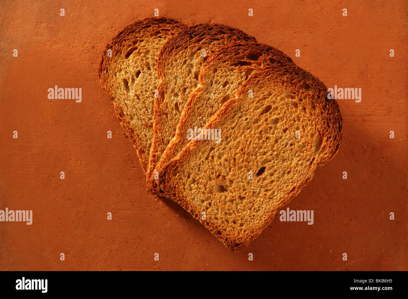 Toasted bread slices over orange clay background Stock Photo - Alamy