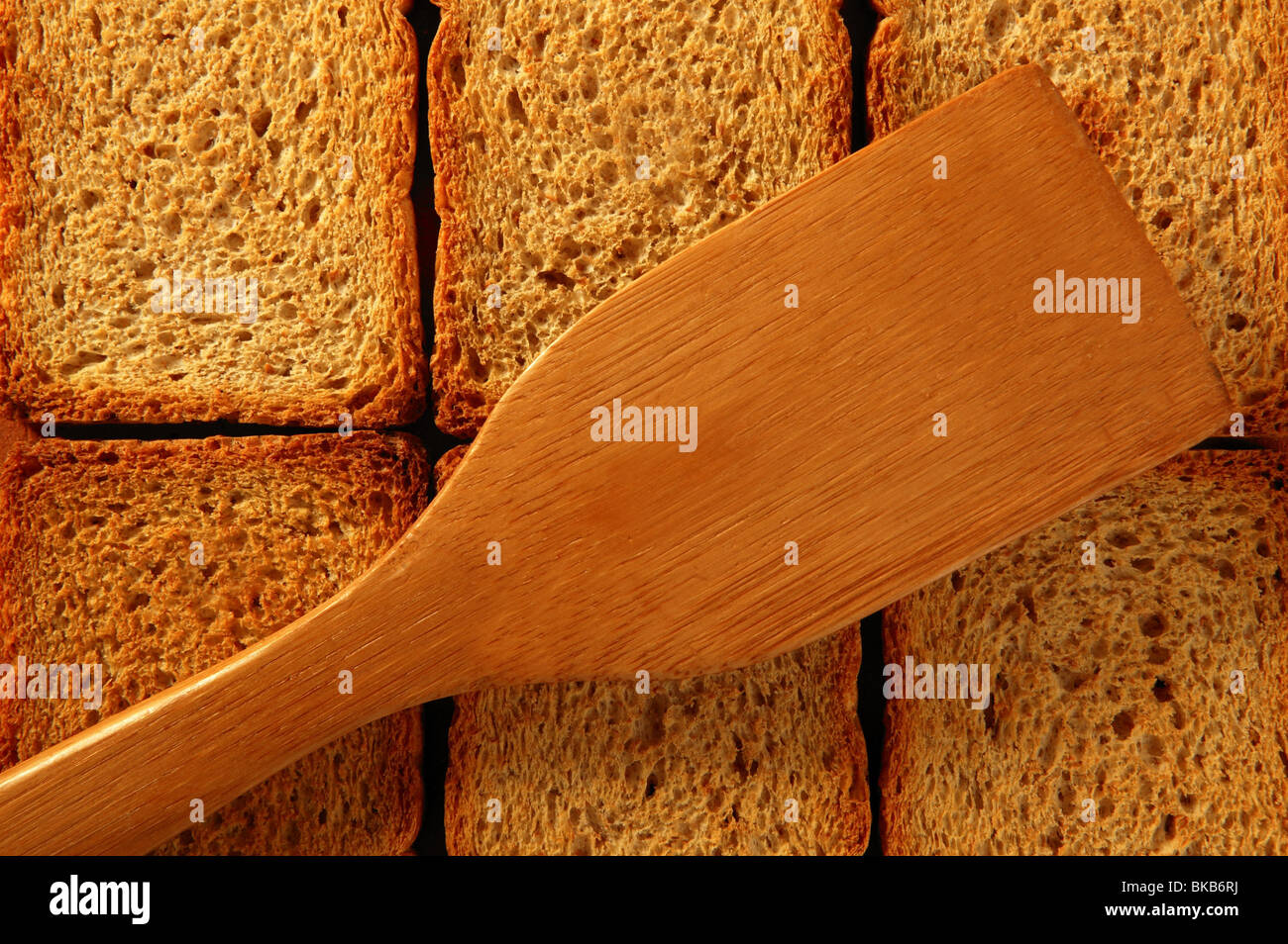 Toasted golden bread slices in rows, wooden bakery shovel Stock Photo ...