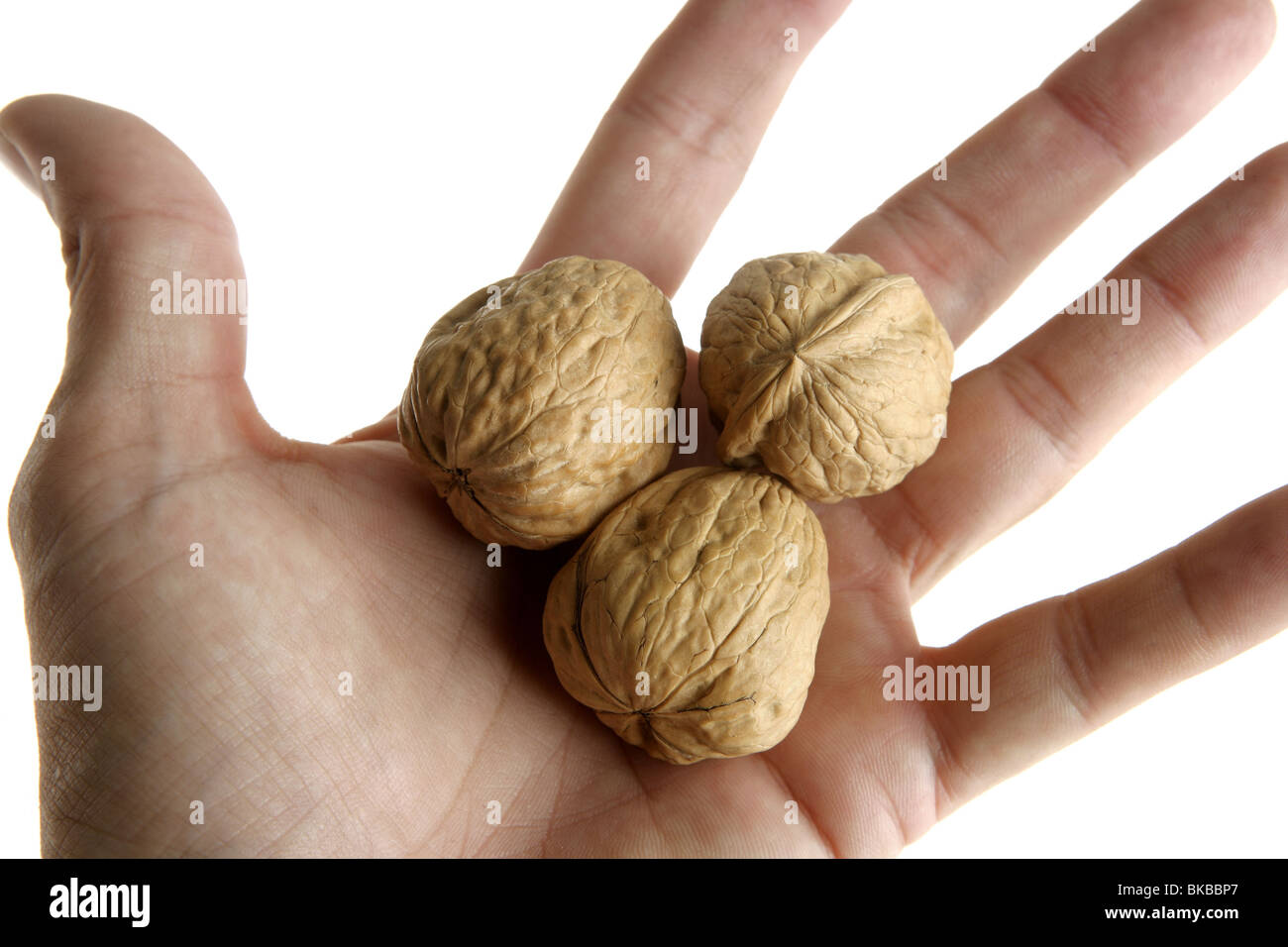 Human hand holding three walnut nuts over white background Stock Photo ...
