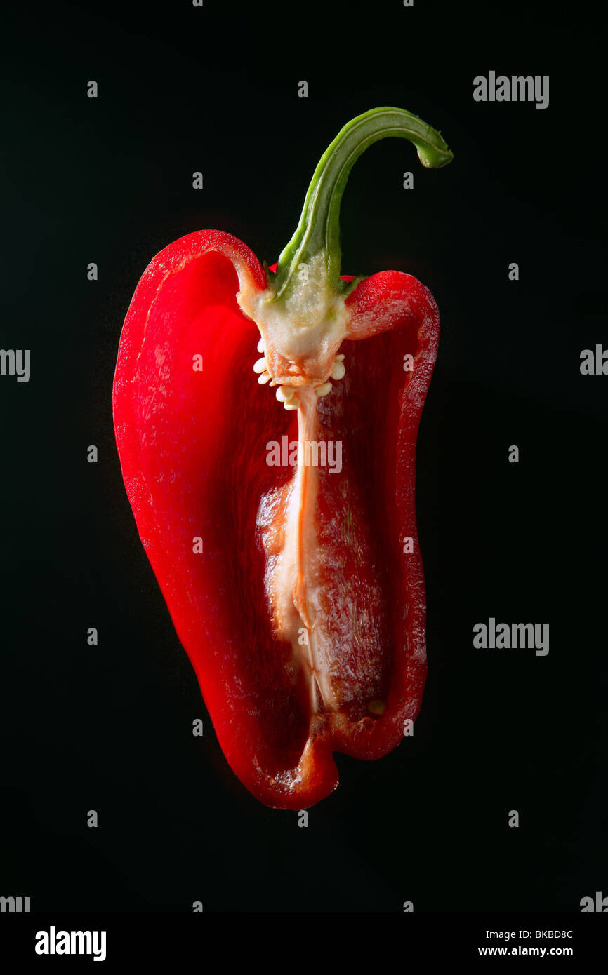 Half cutted red pepper isolated over black background Stock Photo - Alamy