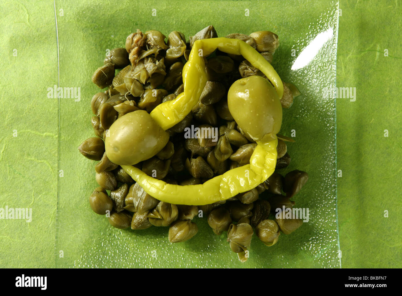 Capers, olives and hot pepper snack , green background Stock Photo - Alamy