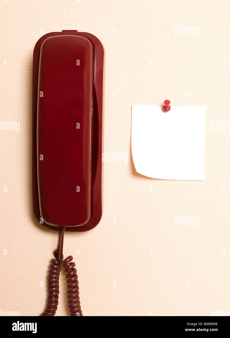 Red telephone is hanging on light brown wall Stock Photo - Alamy