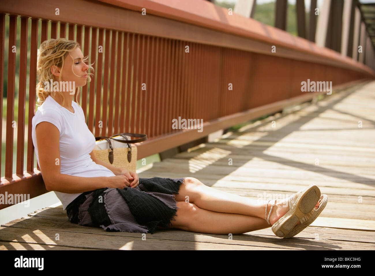 Woman sitting on boardwalk hi-res stock photography and images - Alamy