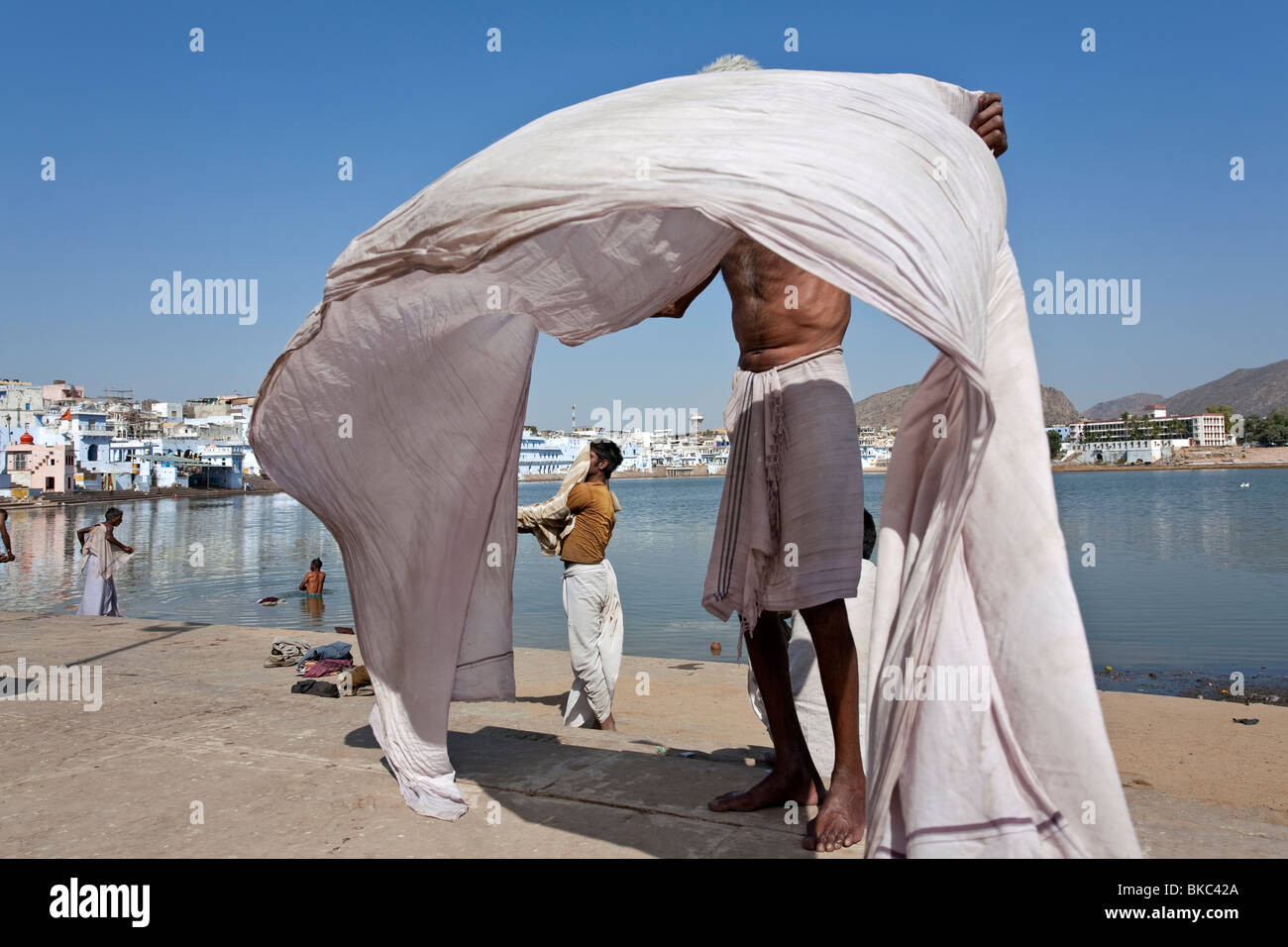 Indian man drying his clothes after the ritual bath. Pushkar Lake ghats ...