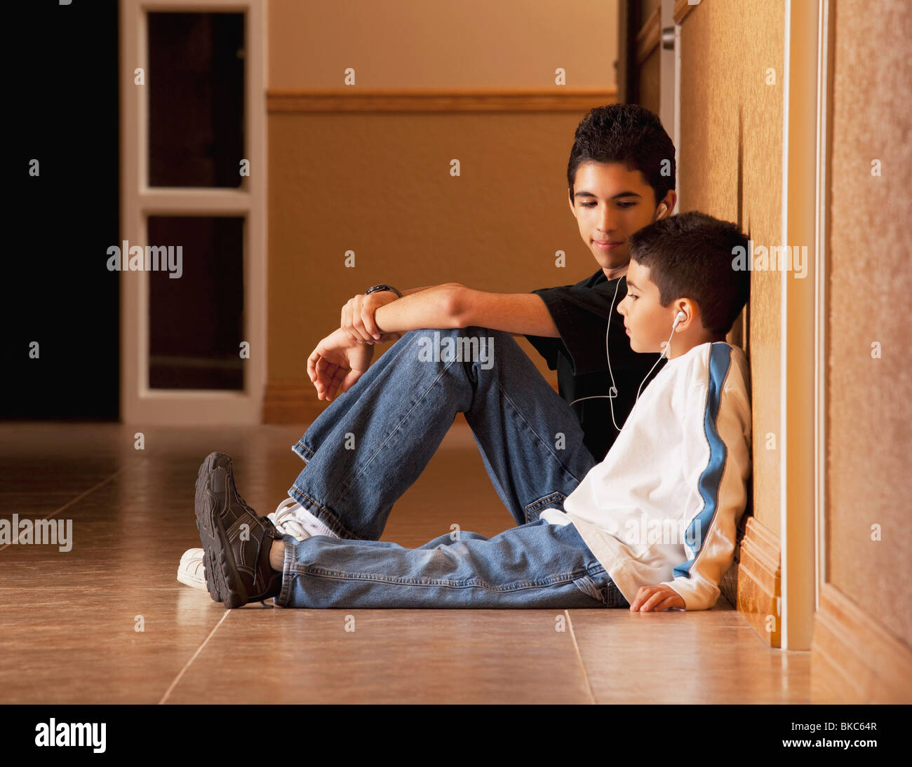 Brothers Sitting On The Floor Listening To Music Stock Photo - Alamy