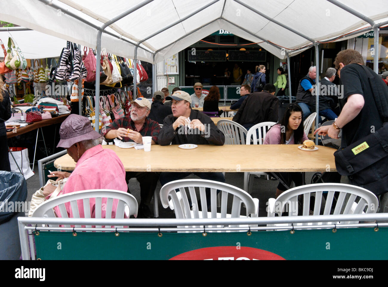 diverse people eating outside at tables provided on Ninth Avenue at New ...