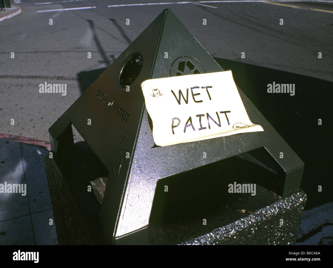 wet paint sign on a trash recycling container Stock Photo - Alamy