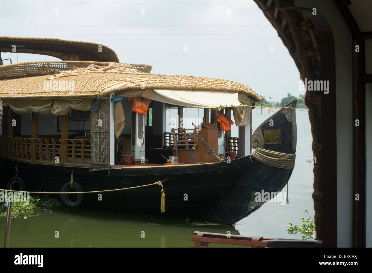 view of a houseboat anchored by the side of the backwater from another ...