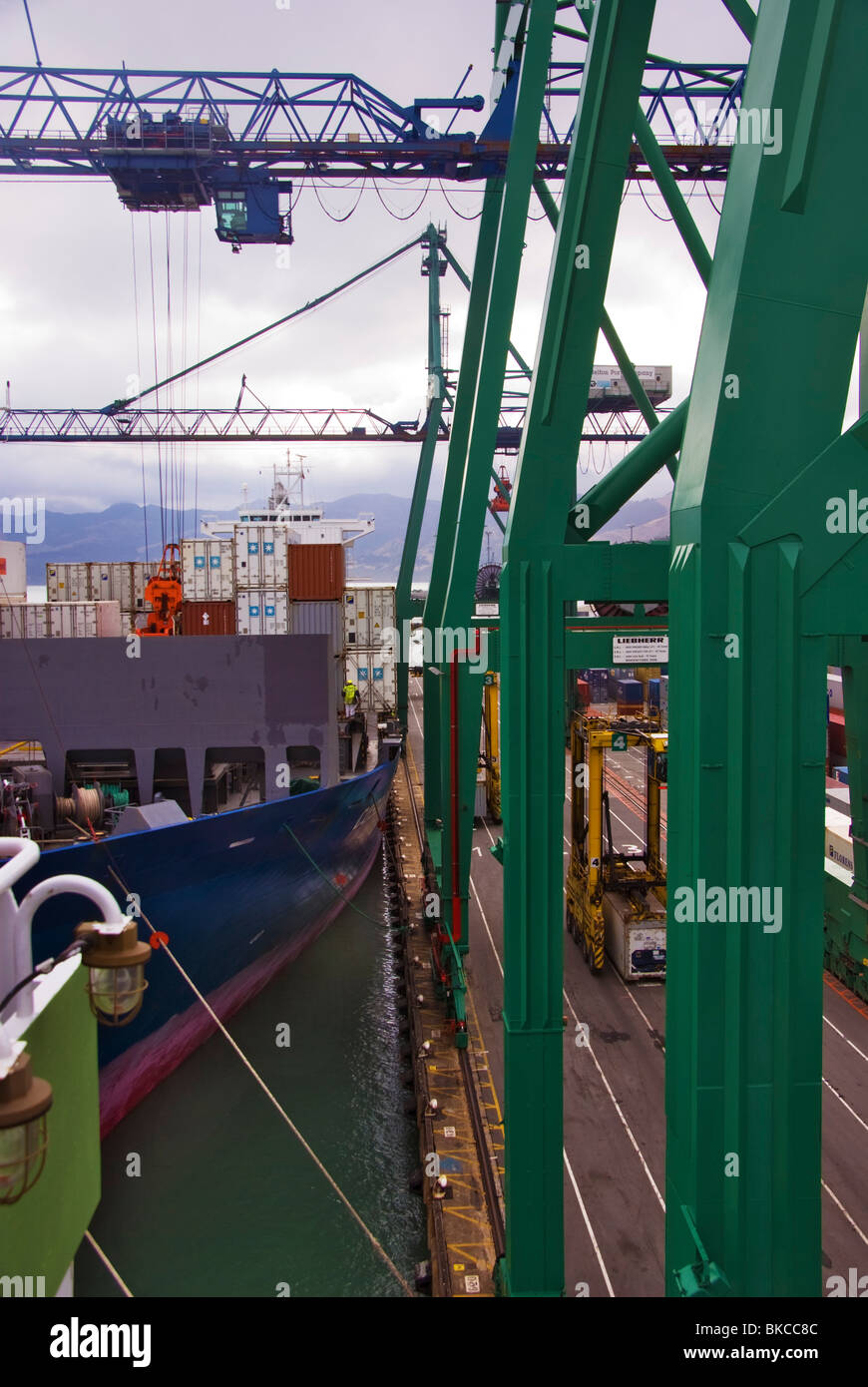 Ship berthed at quayside at container terminal and container cranes ...