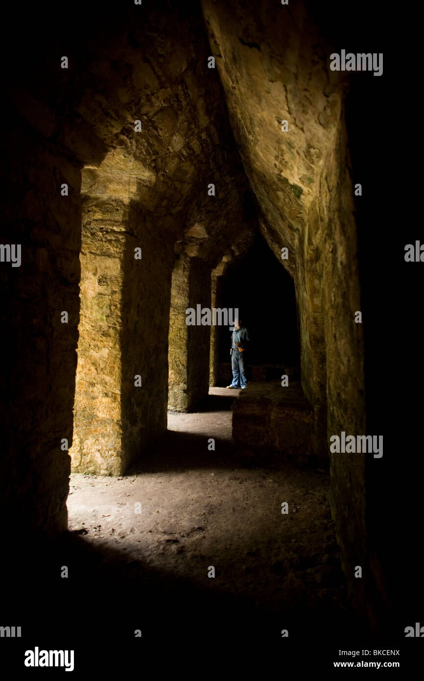A tour guide walks in a passage in Building 19 at the ancient Mayan ...