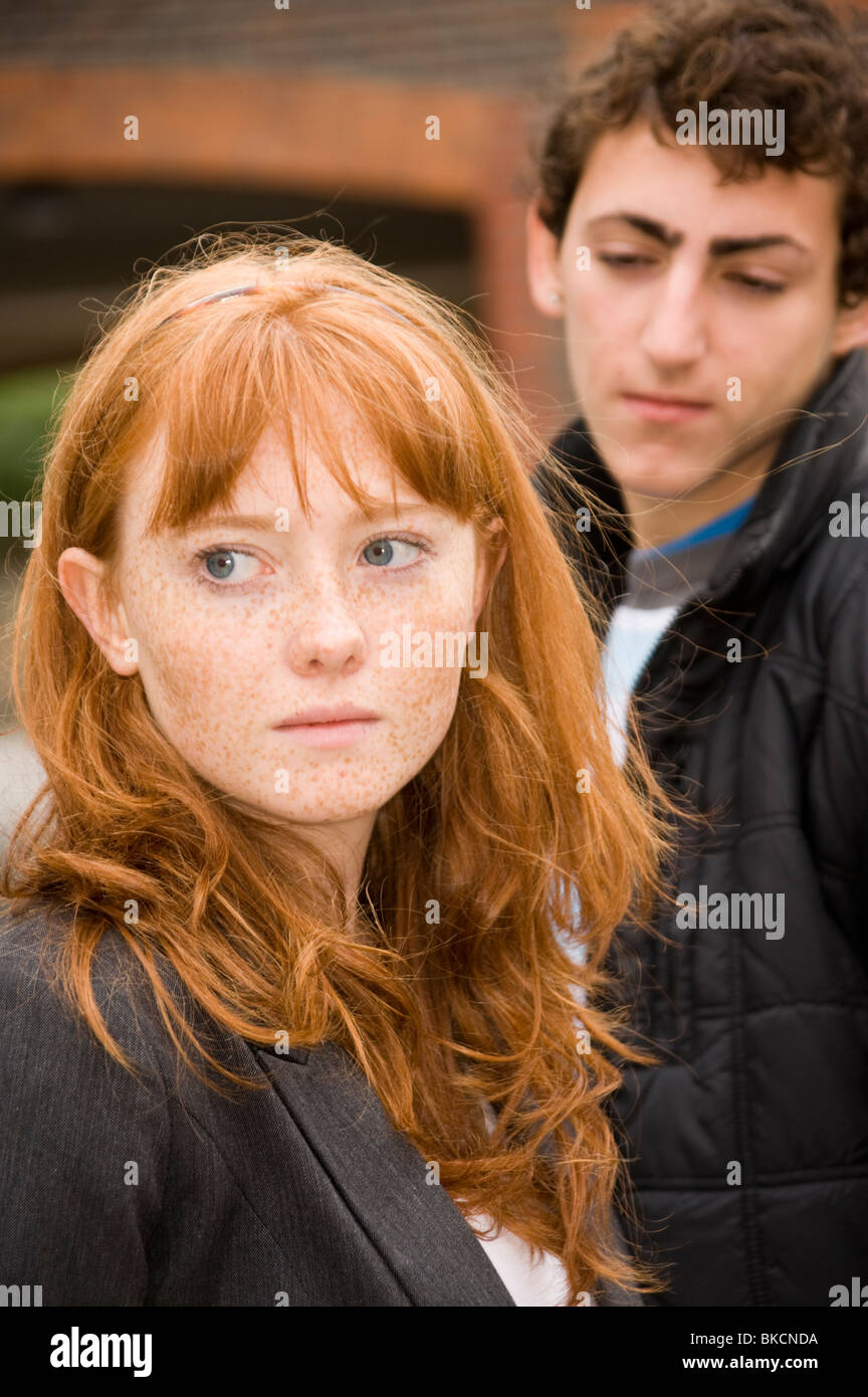 teenage couple with a girl with red hair and freckles in the foreground ...