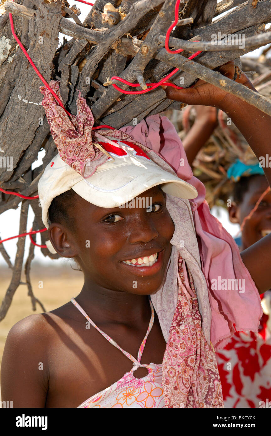 Young firewood collector, African girl carrying a bundle of firewood on ...