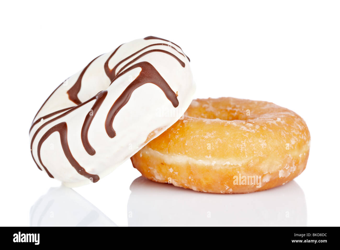 Two delicious donuts reflected on white background with shallow depth ...