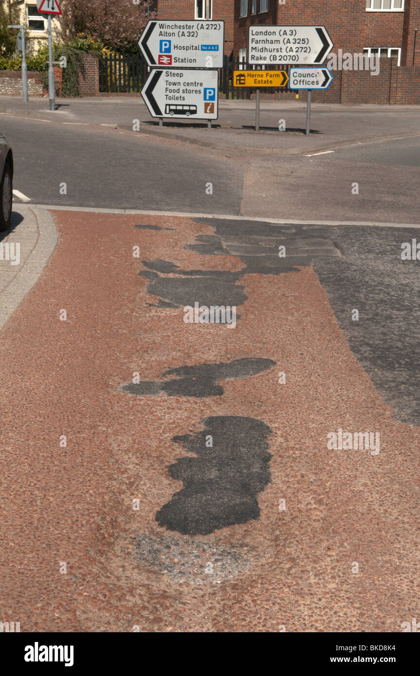 Repaired potholes in road, black tarmac filler in re, pink tarmac Stock ...