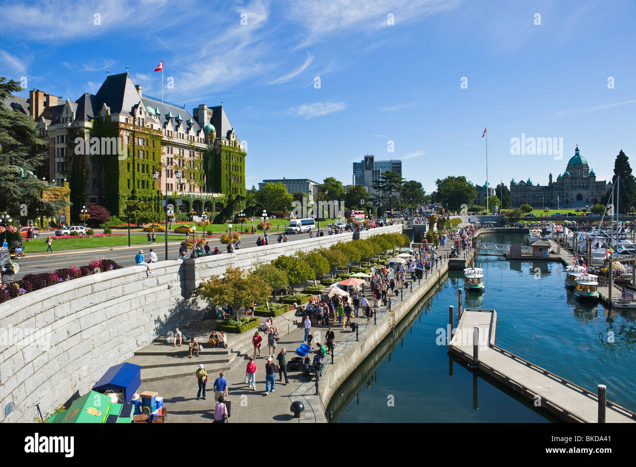tourists walk along harbor waterfront on summer afternoon, Victoria ...