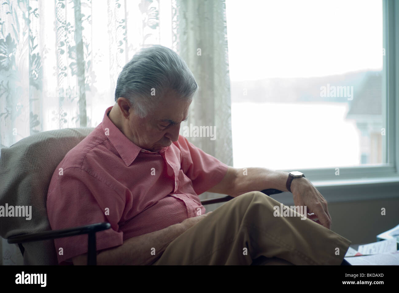 Old man sleeping in living room chair Stock Photo - Alamy