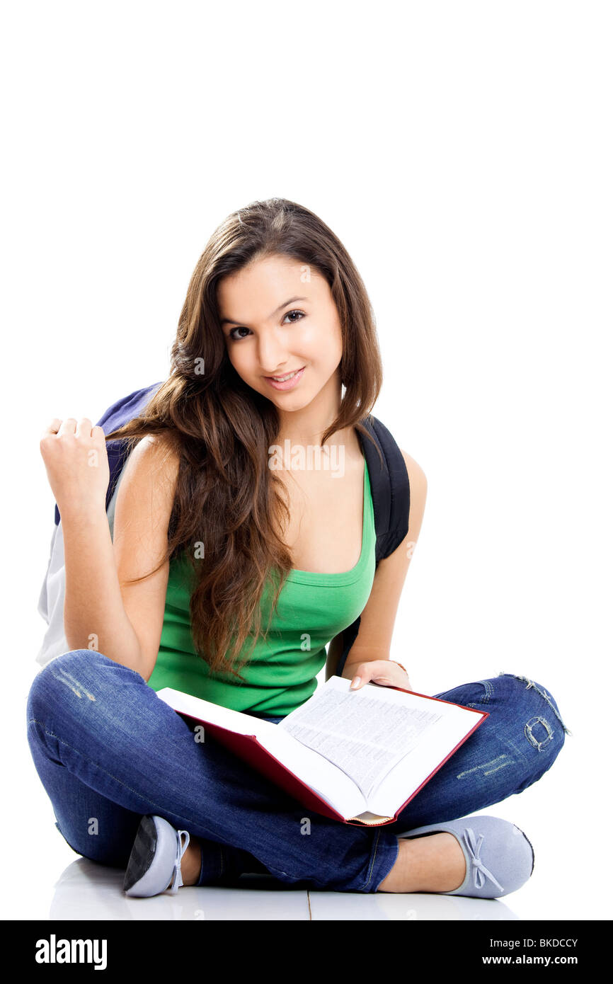 Beautiful young female student sitting on floor studying, isolated on ...